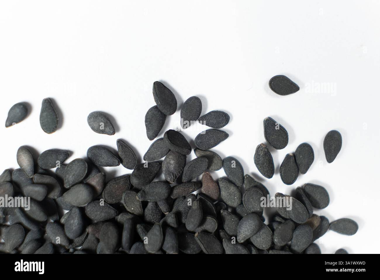 Black sesame seeds scattered on a white background macro top view Stock ...