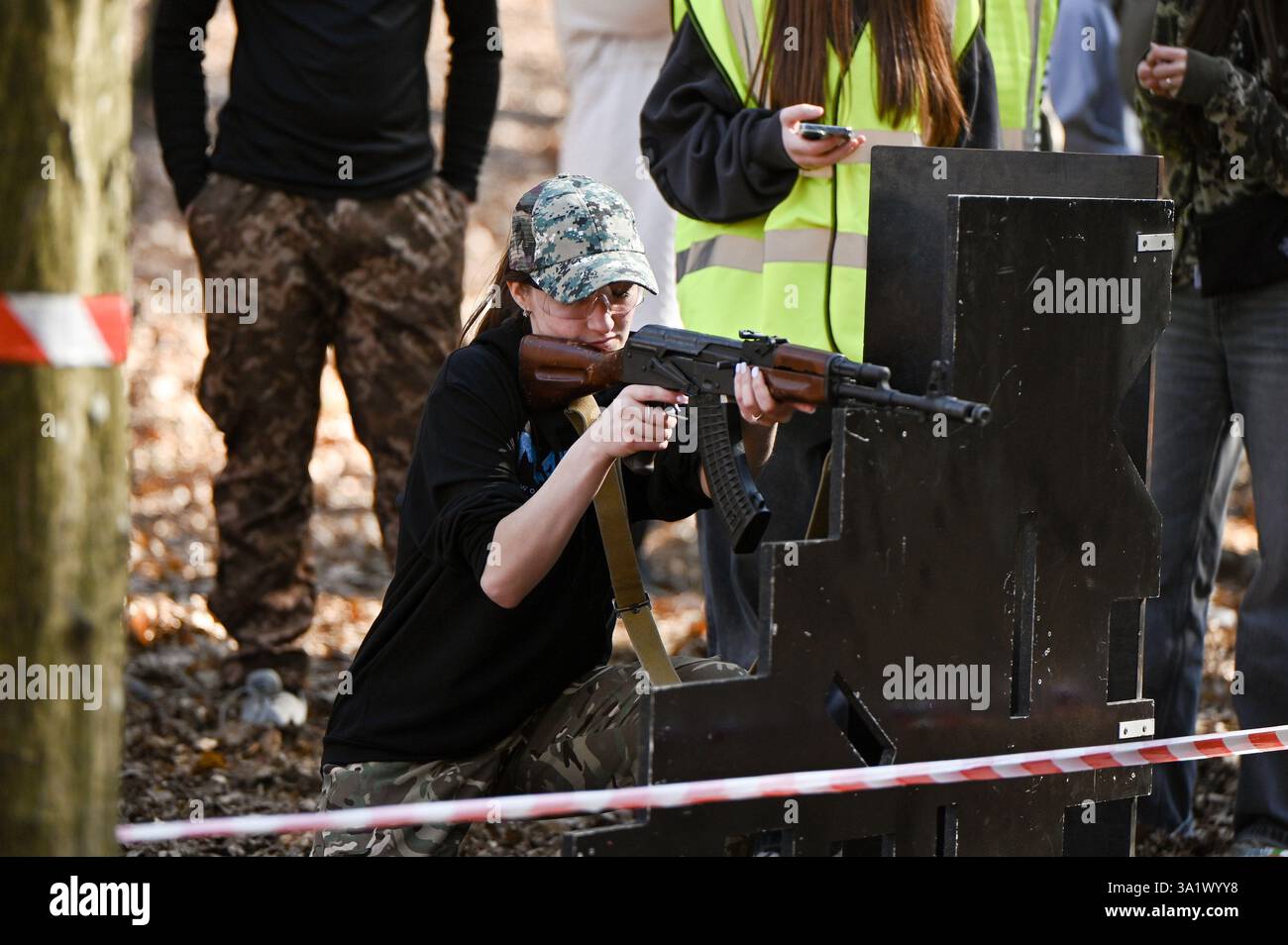 Non Exclusive: A girl in the kneeling position shoots a rifle during a ...