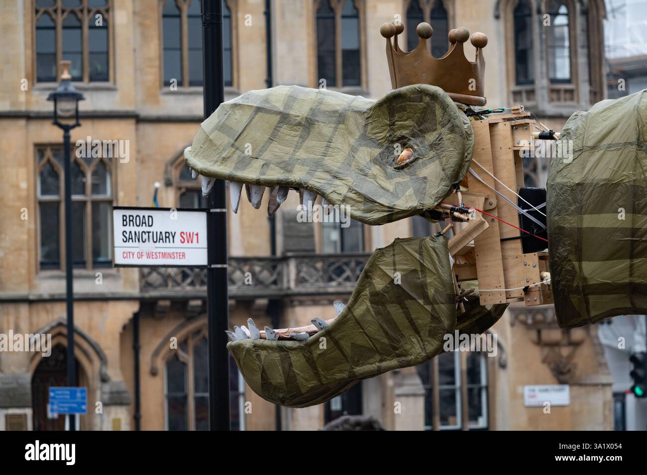 London, UK. 10 March, 2025. A 15ft tall dinosaur puppet wearing a crown ...