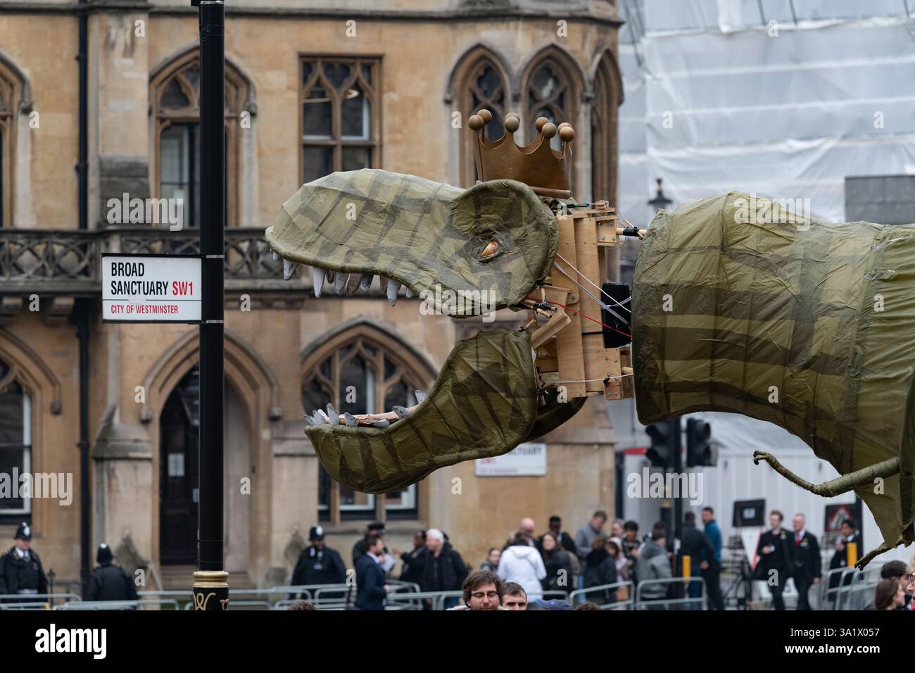 London, UK. 10 March, 2025. A 15ft tall dinosaur puppet wearing a crown ...