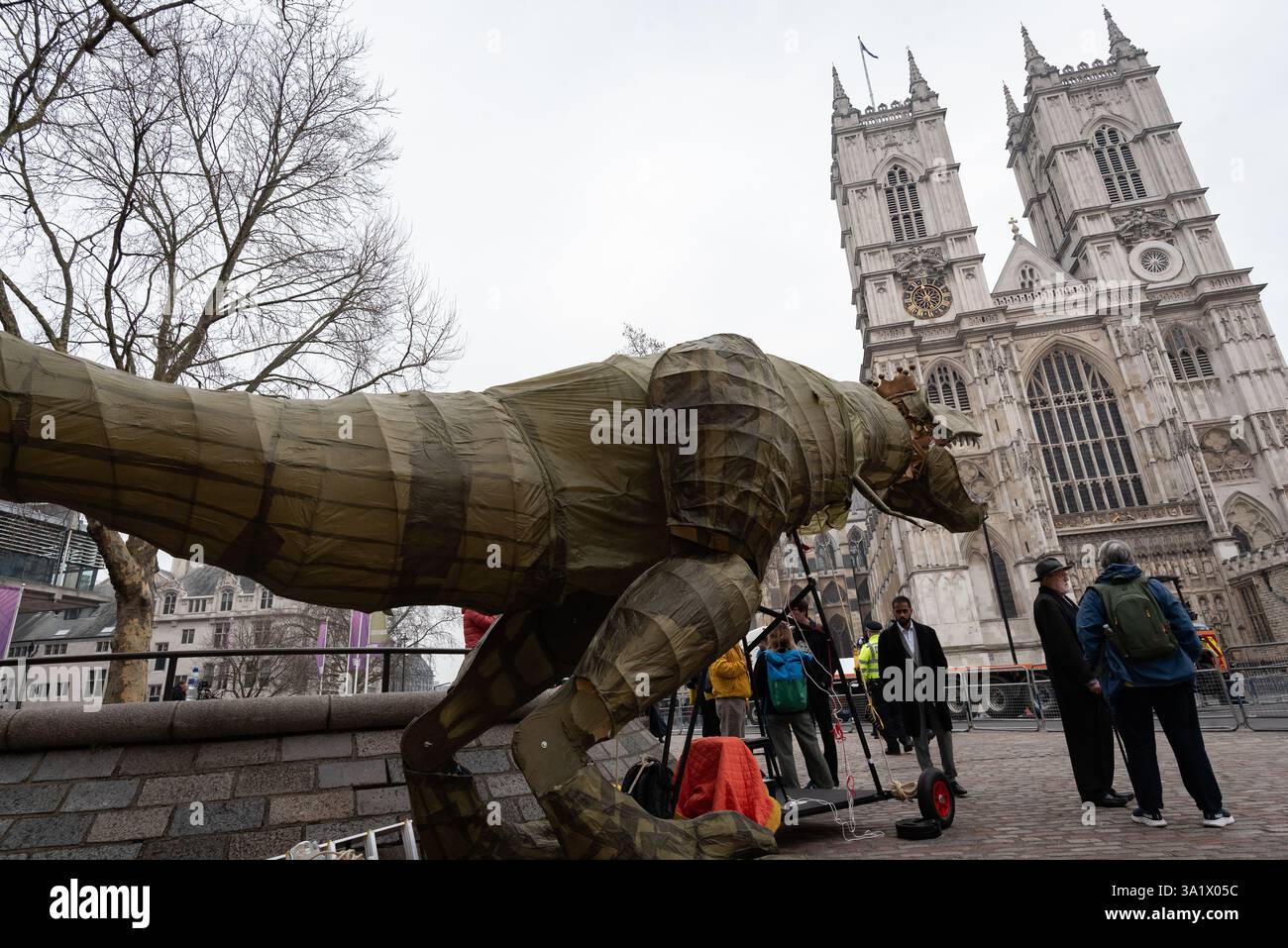 London, UK. 10 March, 2025. A 15ft tall dinosaur puppet wearing a crown ...