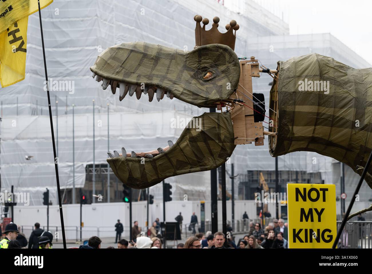 London, UK. 10 March, 2025. A 15ft tall dinosaur puppet wearing a crown ...