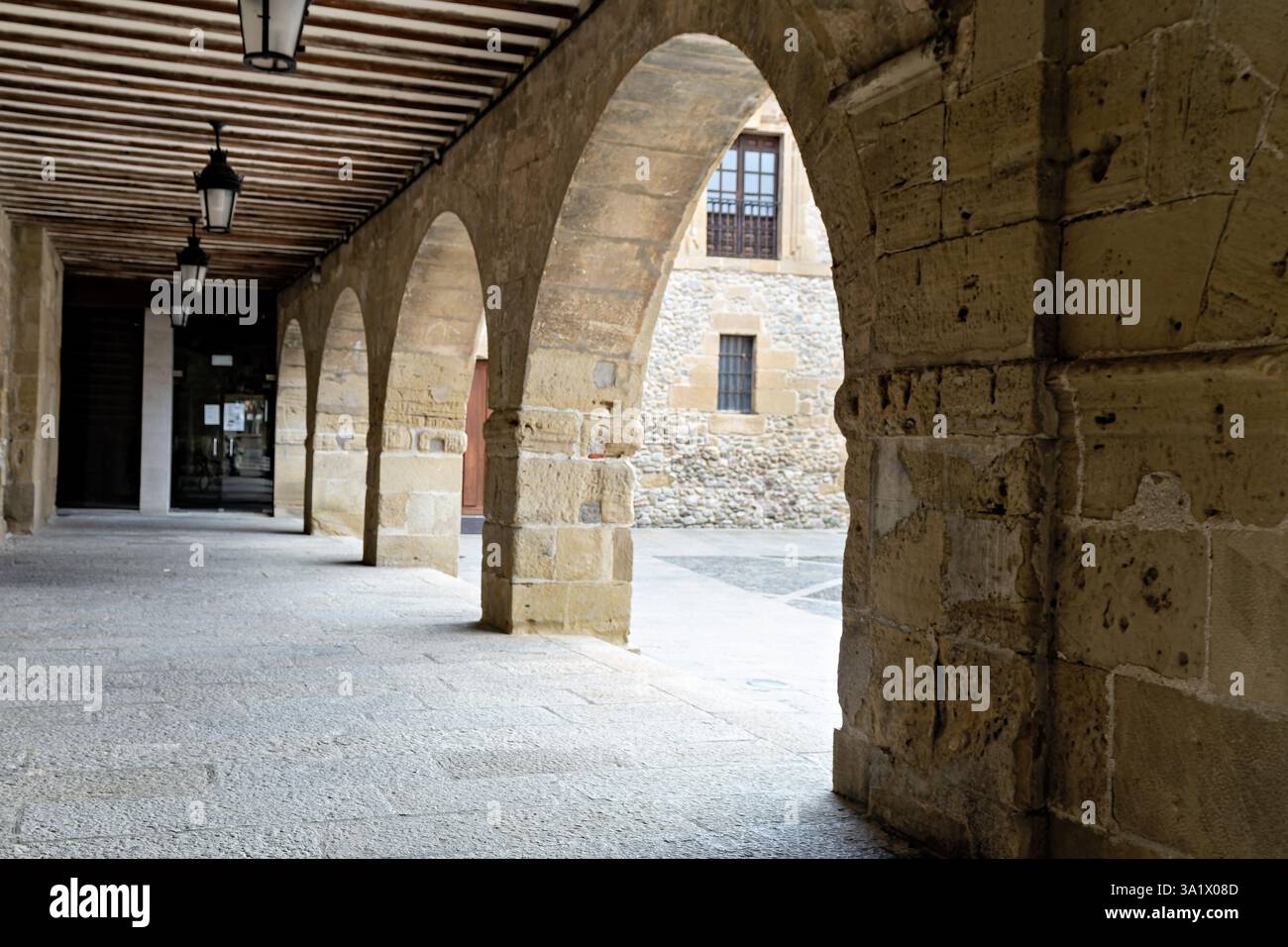 Historic covered arcade with stone arches in Santo Domingo de la ...