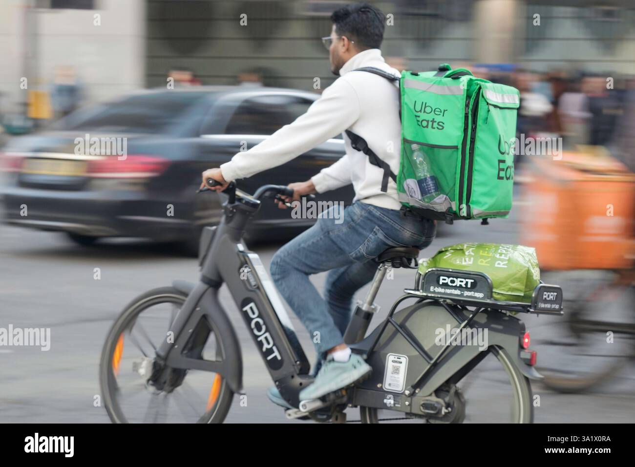 A Uber Eats courier on e-bike on central London street, UK Stock Photo ...