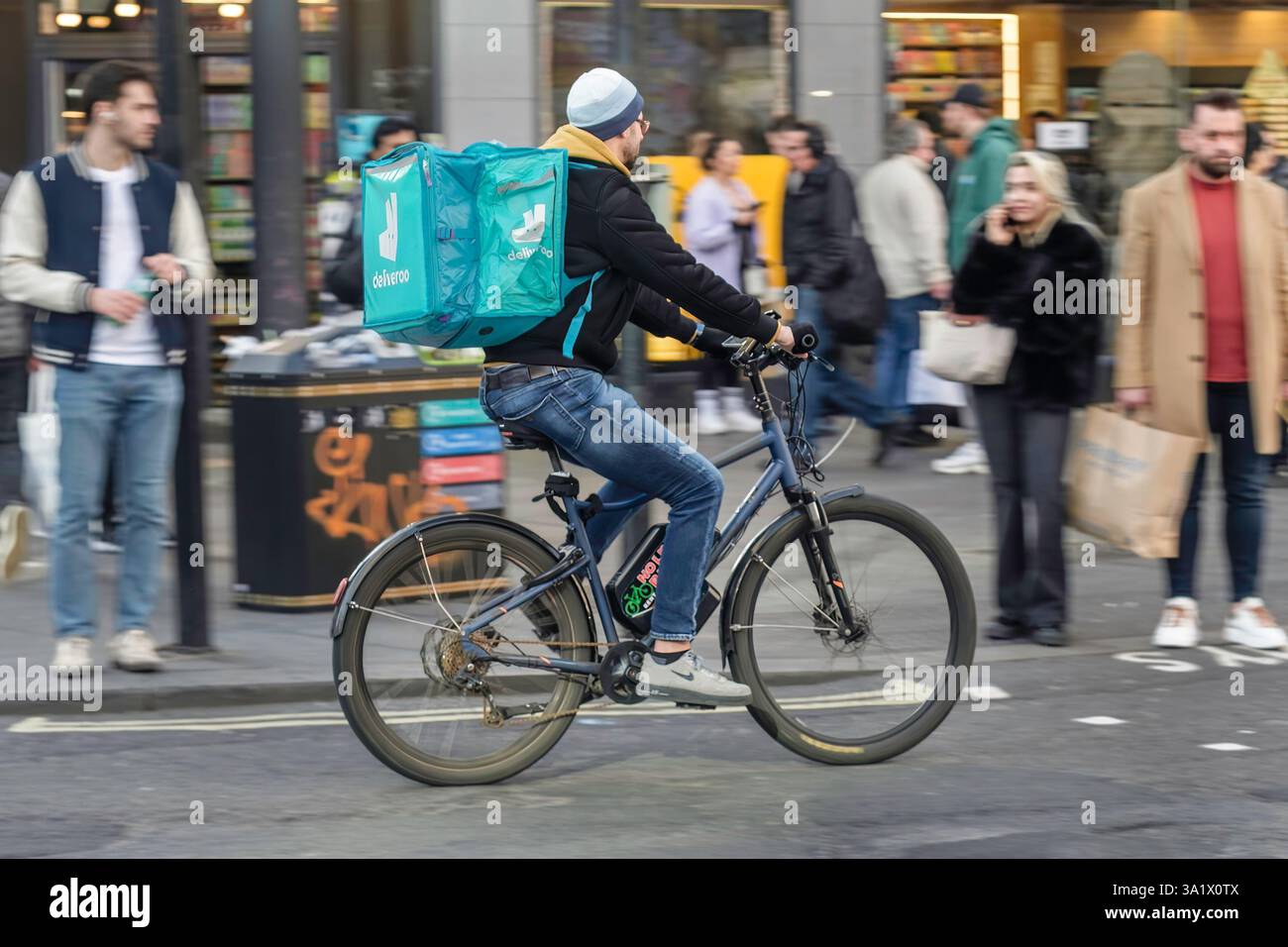 A deliveroo courier on e-bike on central London street, UK Stock Photo ...