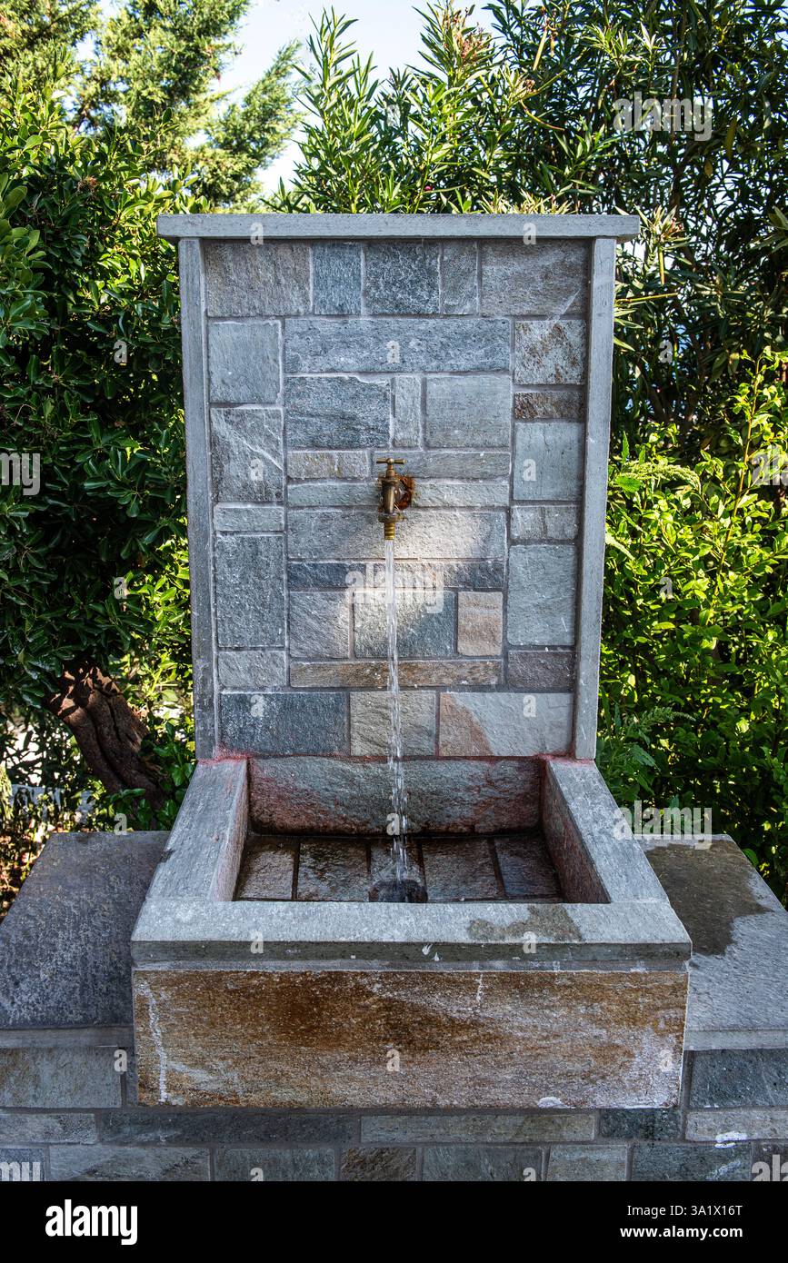 Outdoor tap with valve open allowing a full flow of water. The tap is ...