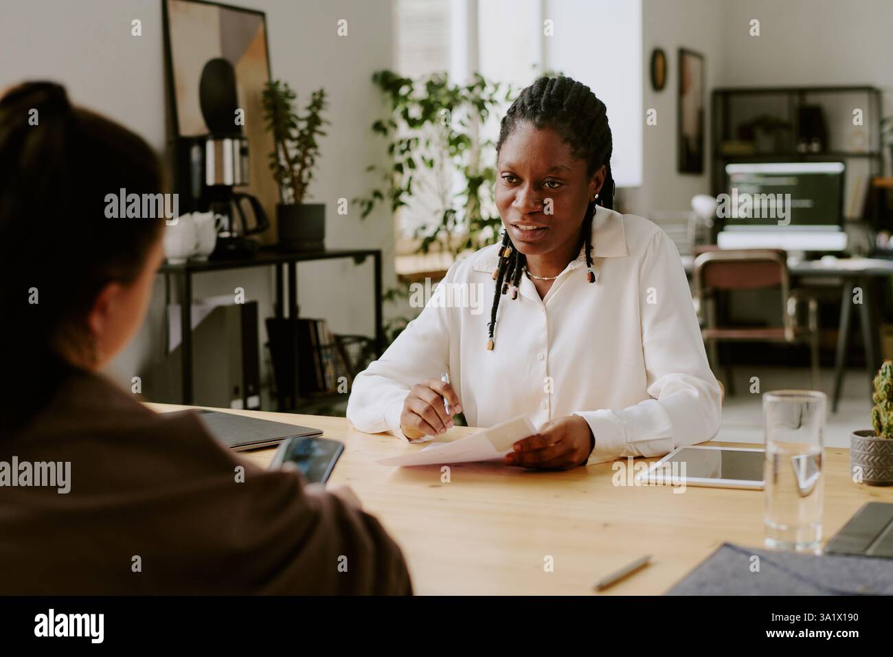 Medium shot of professional African American job interviewer holding ...