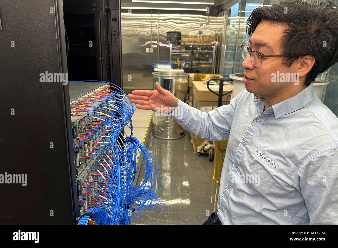 Jerry Chow, IBM Fellow and Director of Quantum Infrastructure, is with electronic cables used to ...