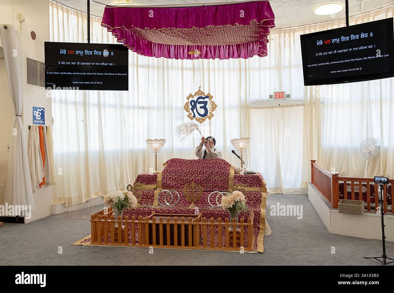 A priest waves a white Chaur Sahib over the Sikh holy book the Guru ...