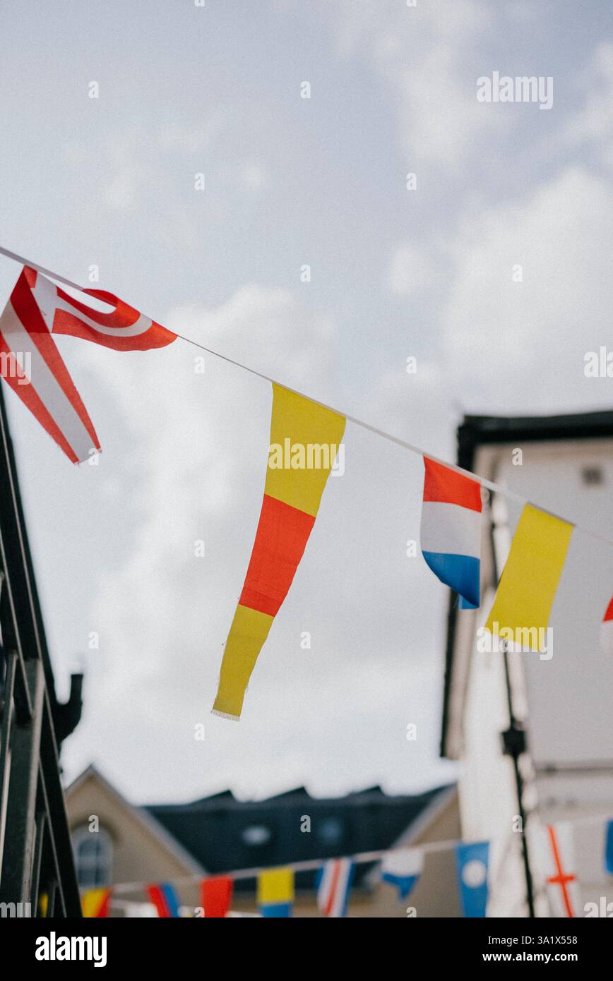 A bunch of flags are hanging from a pole, with some of them being red ...