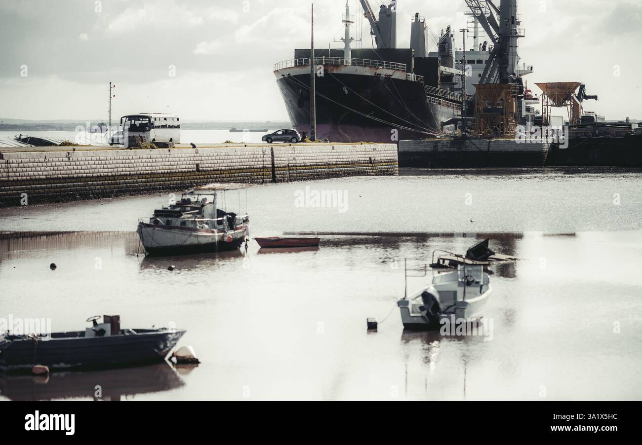 A telephoto shot of a harbor scene with small boats floating in calm ...