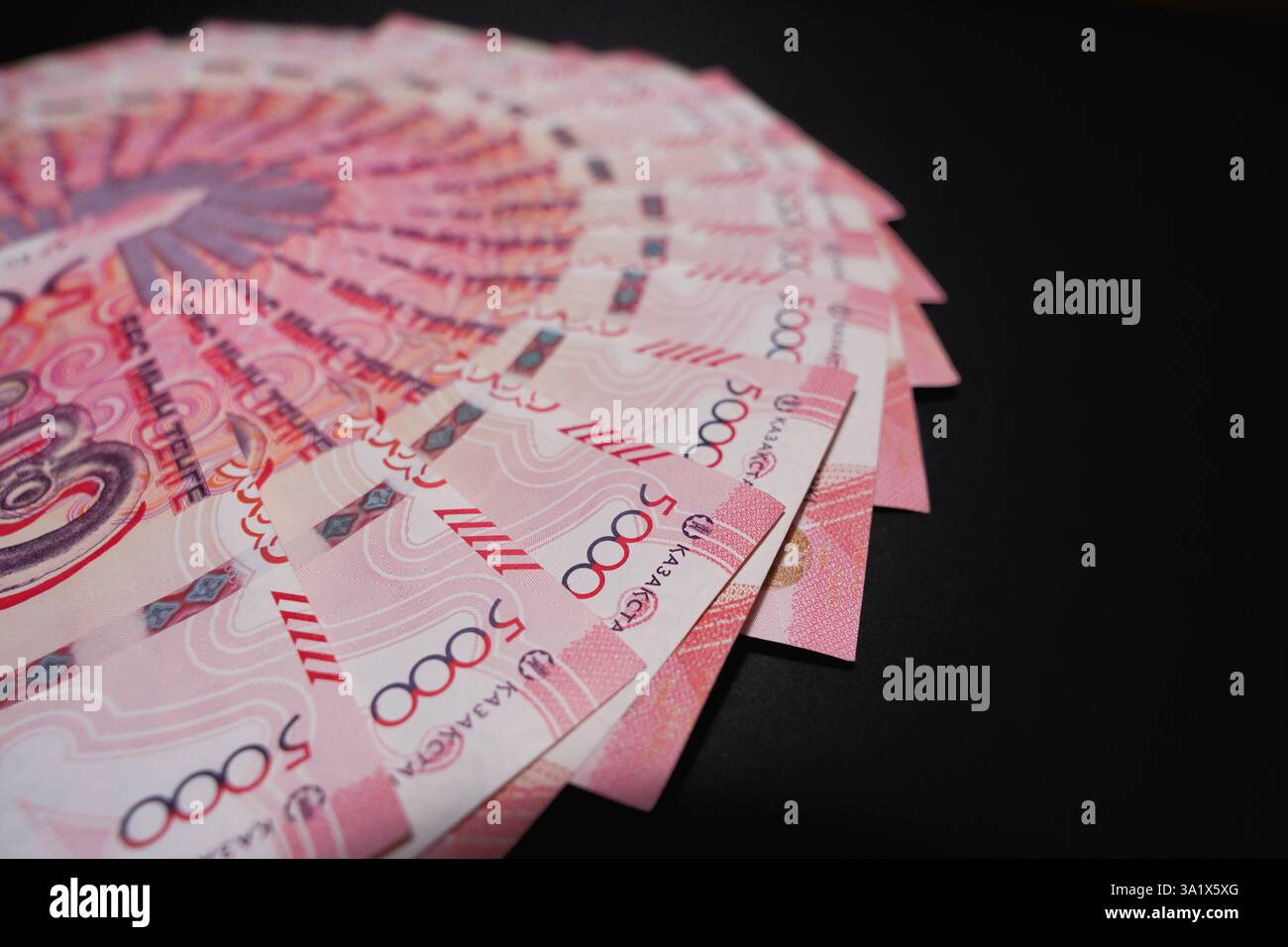 Fan of 5000 tenge banknotes on a black background. Paper money from ...