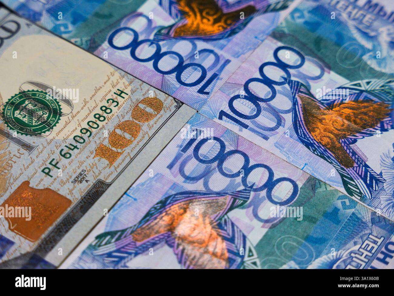 New 100 dollar and 10,000 tenge notes connected at the corners. Paper ...