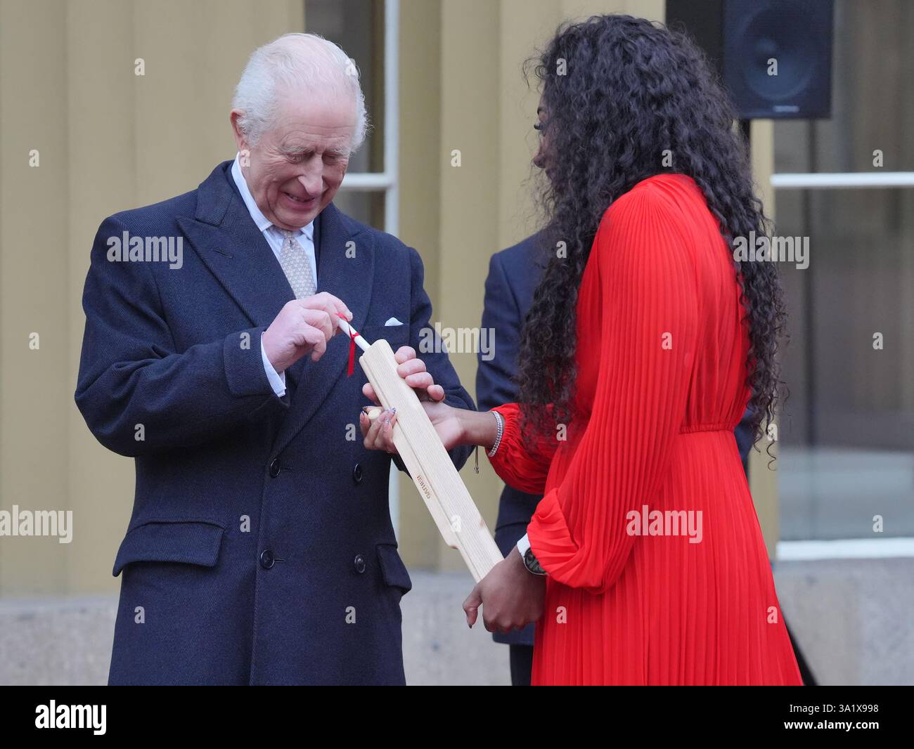 King Charles III places his message into the Commonwealth baton which ...