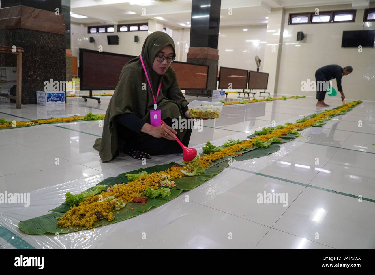 Denpasar resident serves a communal iftar meal, known as Megibung, at ...