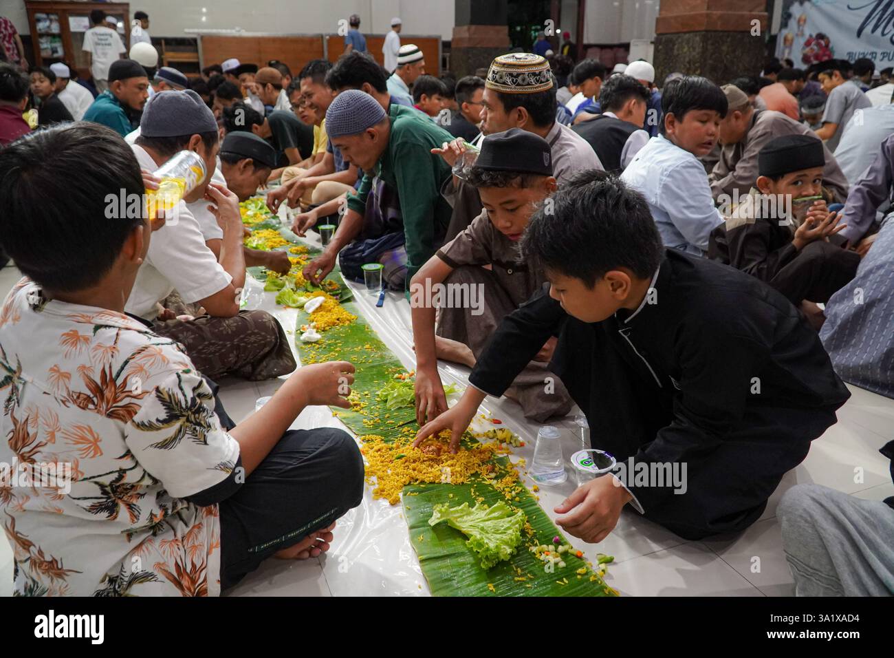Denpasar residents enjoy a communal iftar meal, known as Megibung, at ...