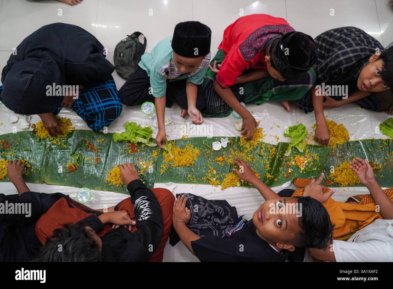 Denpasar residents enjoy a communal iftar meal, known as Megibung, at ...