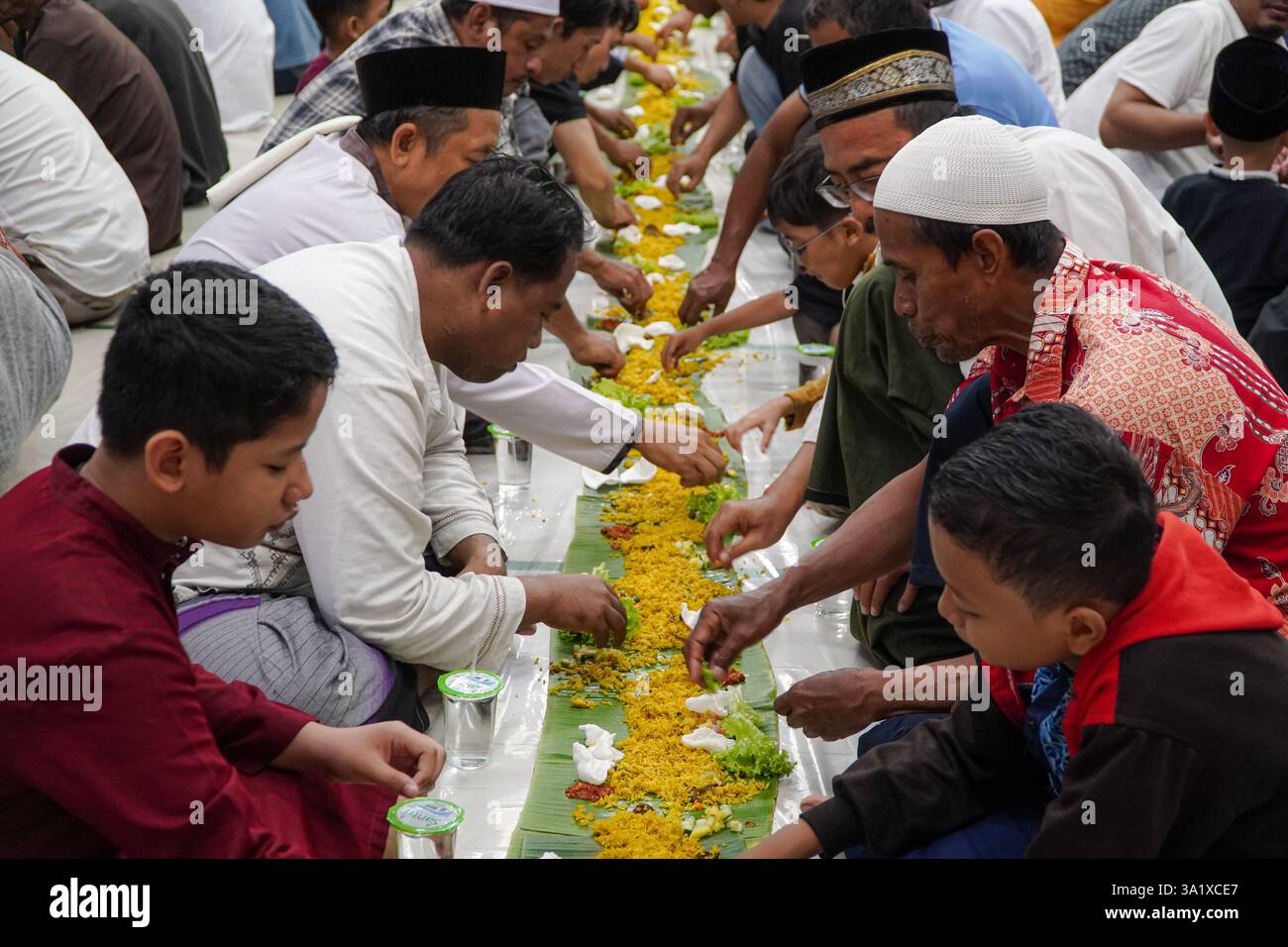 Denpasar residents enjoy a communal iftar meal, known as Megibung, at ...
