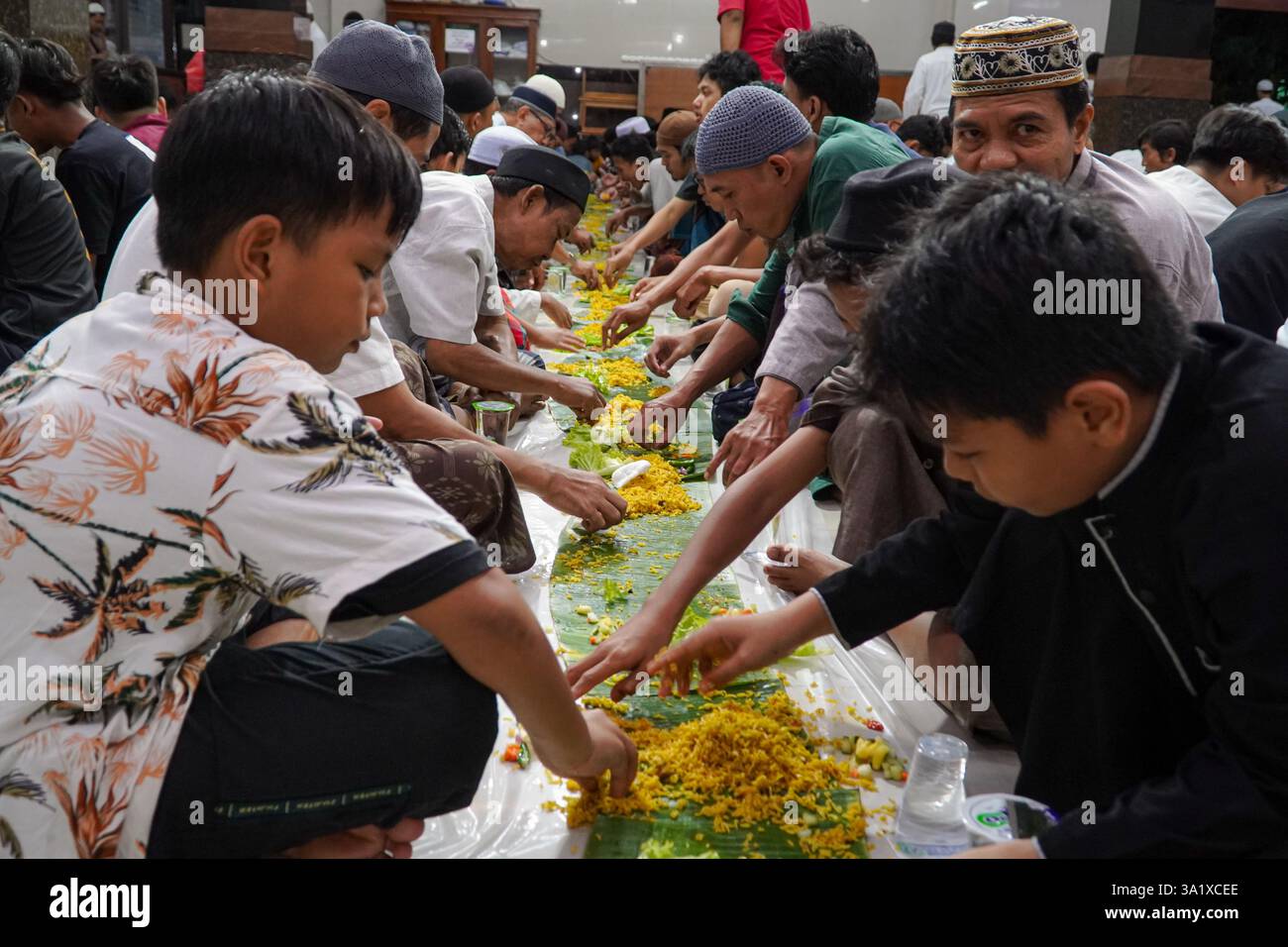 Denpasar residents enjoy a communal iftar meal, known as Megibung, at ...
