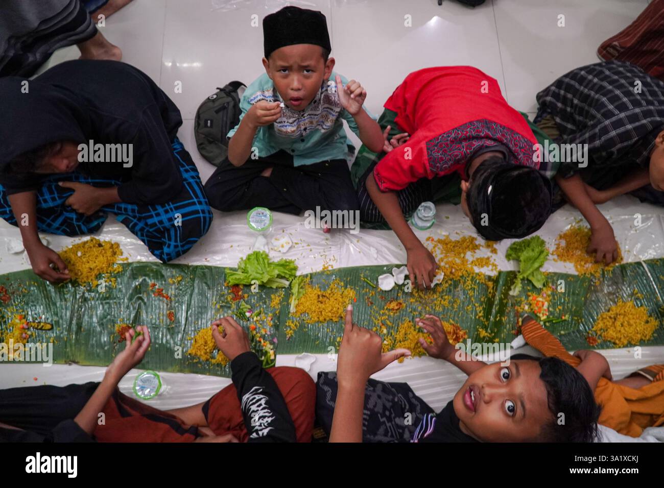 Denpasar residents enjoy a communal iftar meal, known as Megibung, at ...
