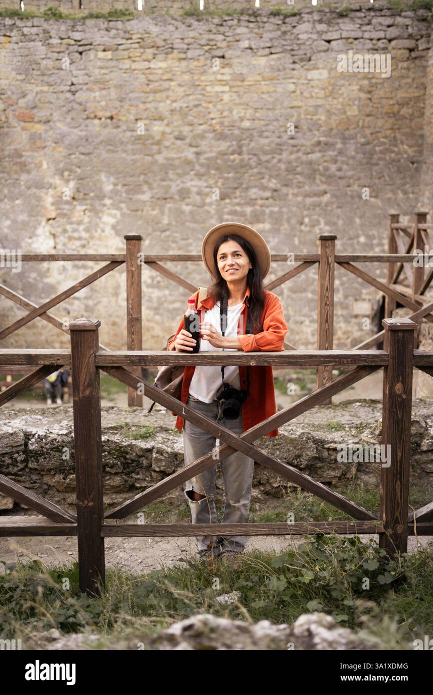 Woman traveling through ancient stone castle walls, discovering ...