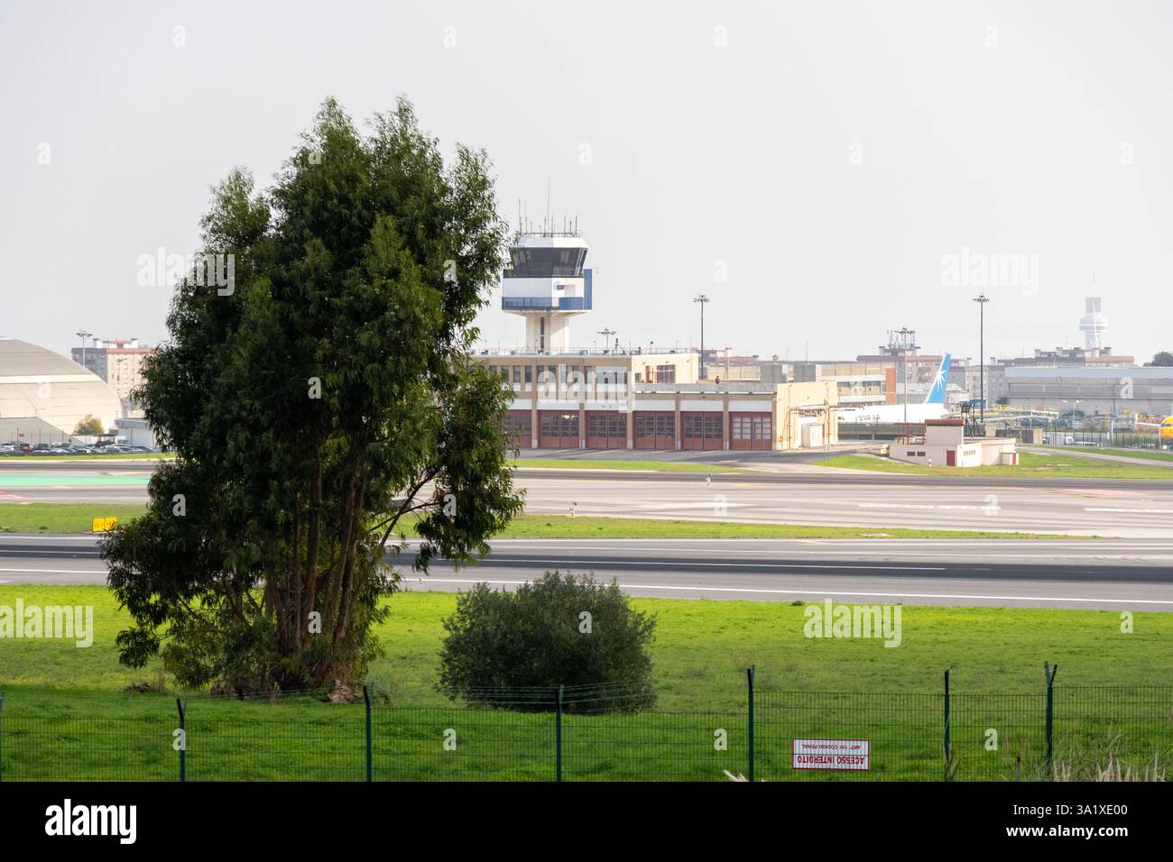 Lisbon humberto delgado airport control tower overseeing planes taking off and landing on a ...