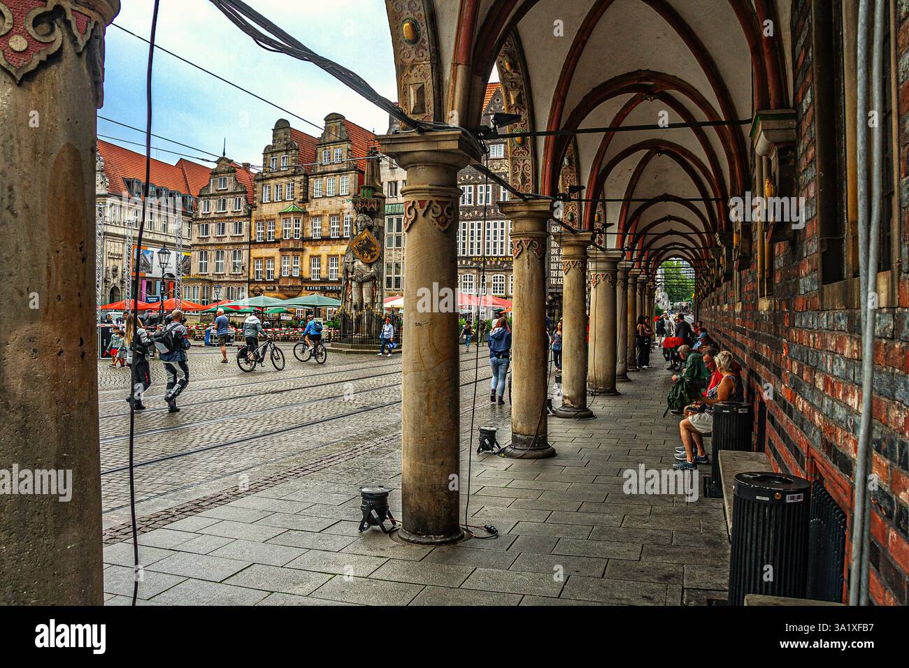 Tourists enjoying a cloudy day under the arches of Bremen Town Hall in ...
