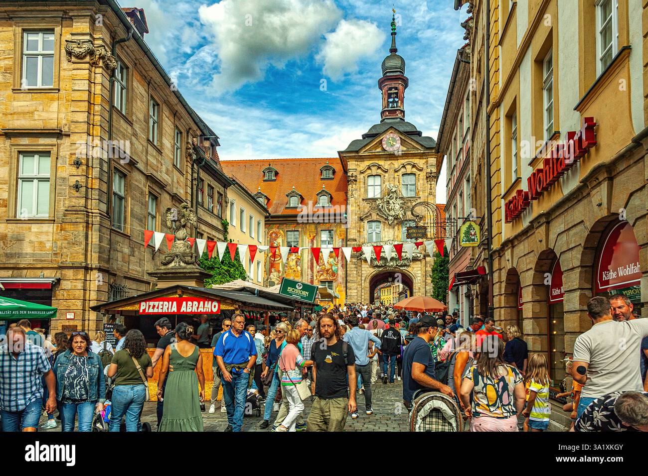 Tourists and locals stroll past the historic Old Town Hall, browsing ...