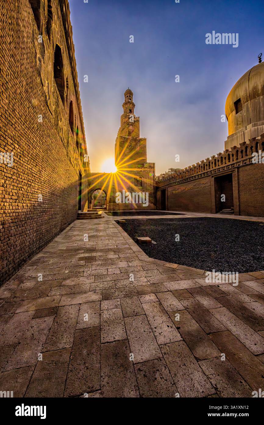 Sun sets behind the minaret at the Ibn Tulun Mosque in Cairo Stock ...