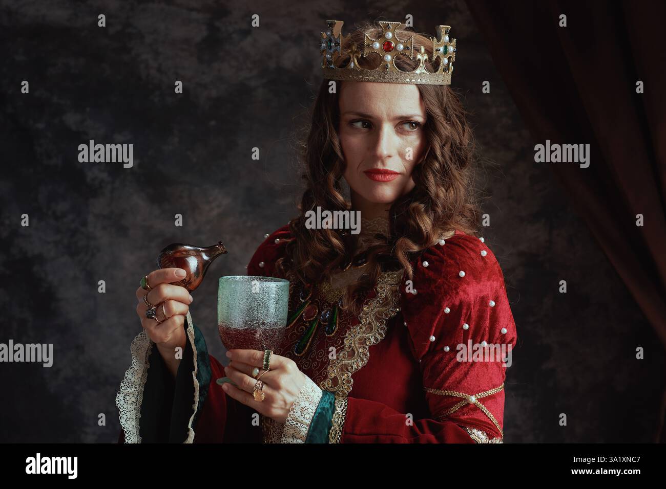 pensive medieval queen in red dress with crown pouring poison into the ...