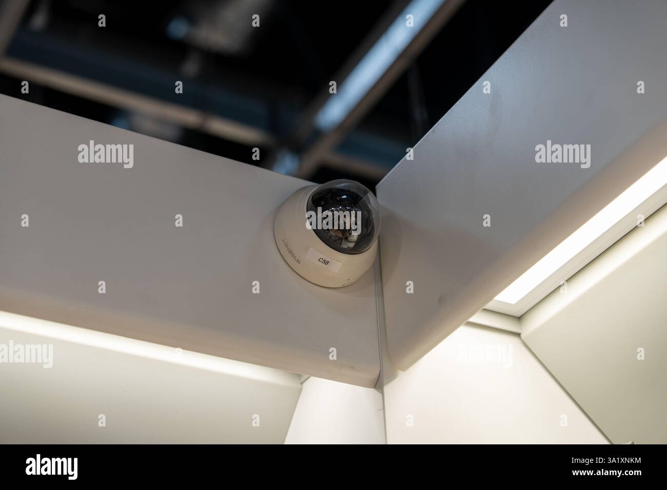 Security camera mounted in a modern interior space capturing an ...