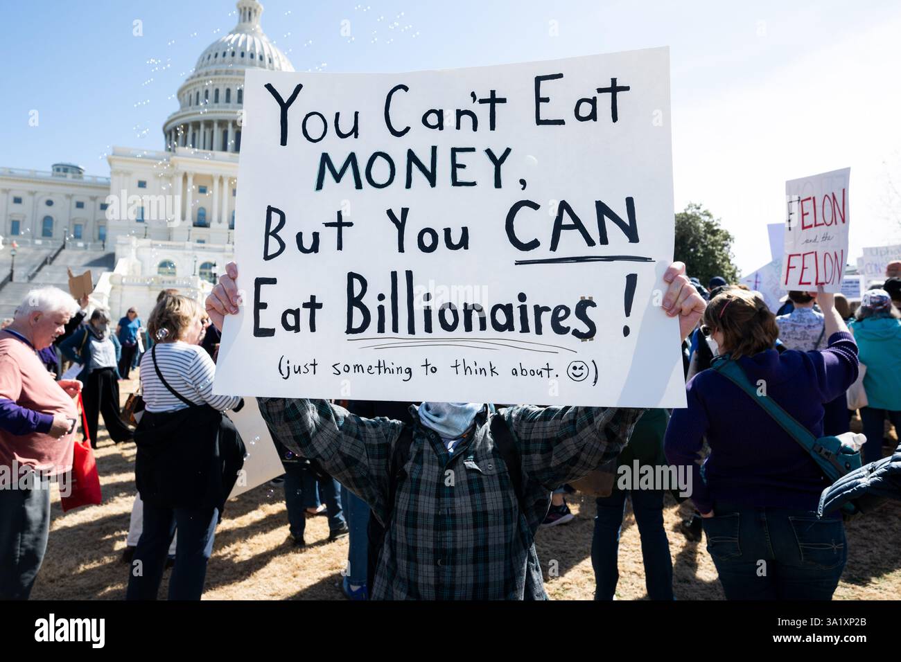 A sign saying "You can't eat money but you can eat billionaires! (just ...