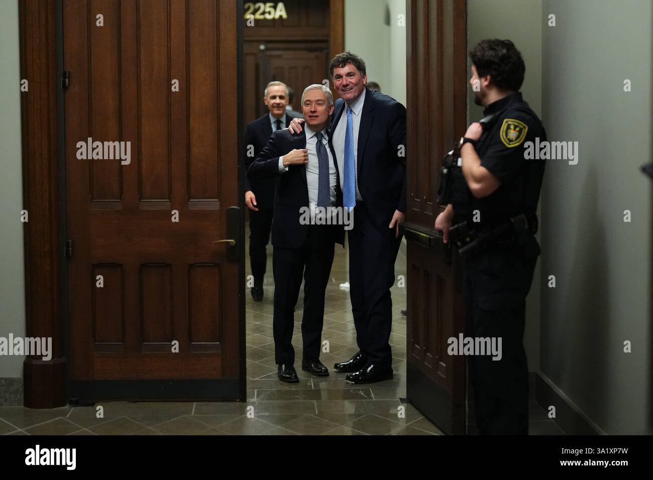 Ottawa, Canada. 10th Mar, 2025. Liberal Leader Mark Carney (back) looks ...
