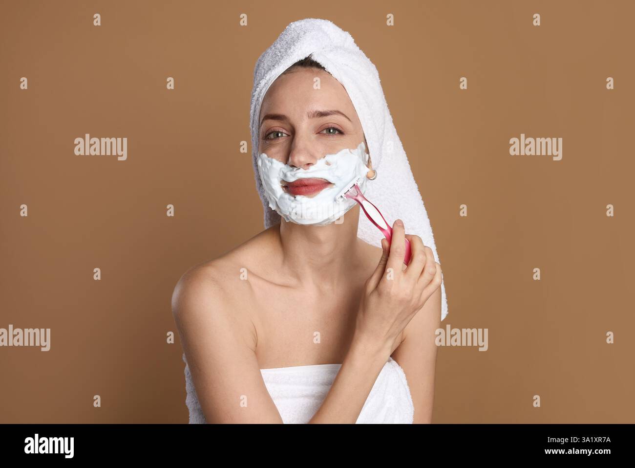 Funny woman shaving facial hair with razor on brown background Stock ...