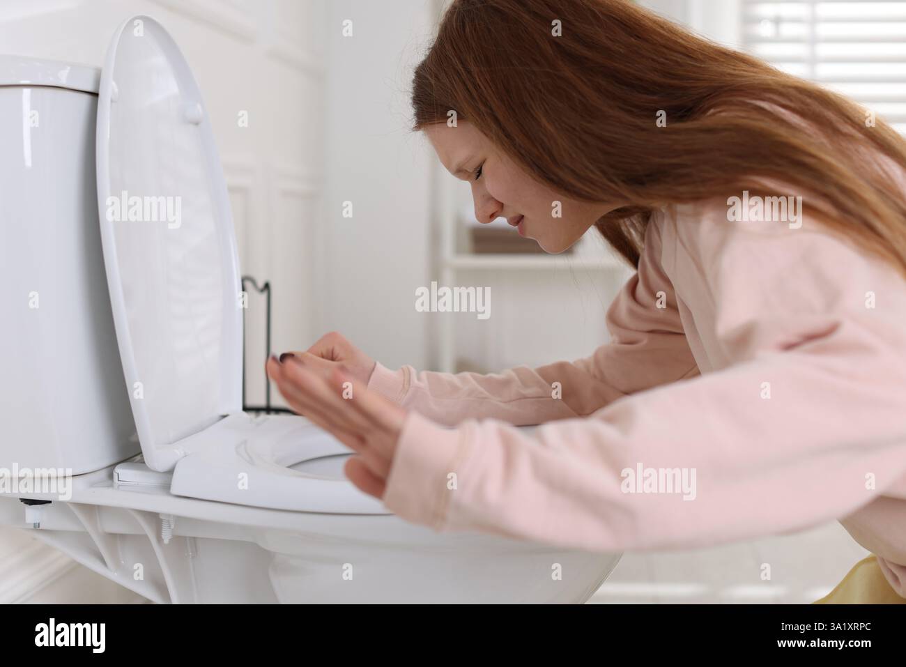 Teenage girl suffering from nausea over toilet bowl and making stop ...