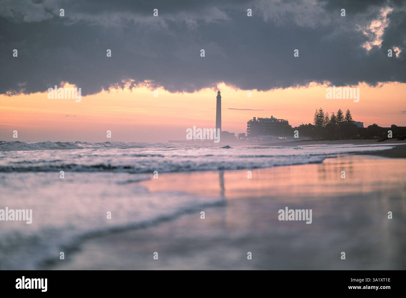 Romantic sunset over the sea with a lighthouse and stormy clouds Stock ...