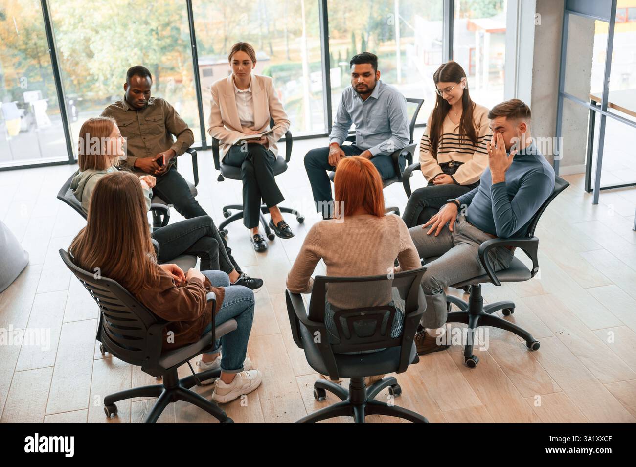 On the chairs. Group of people are having therapy meeting together ...