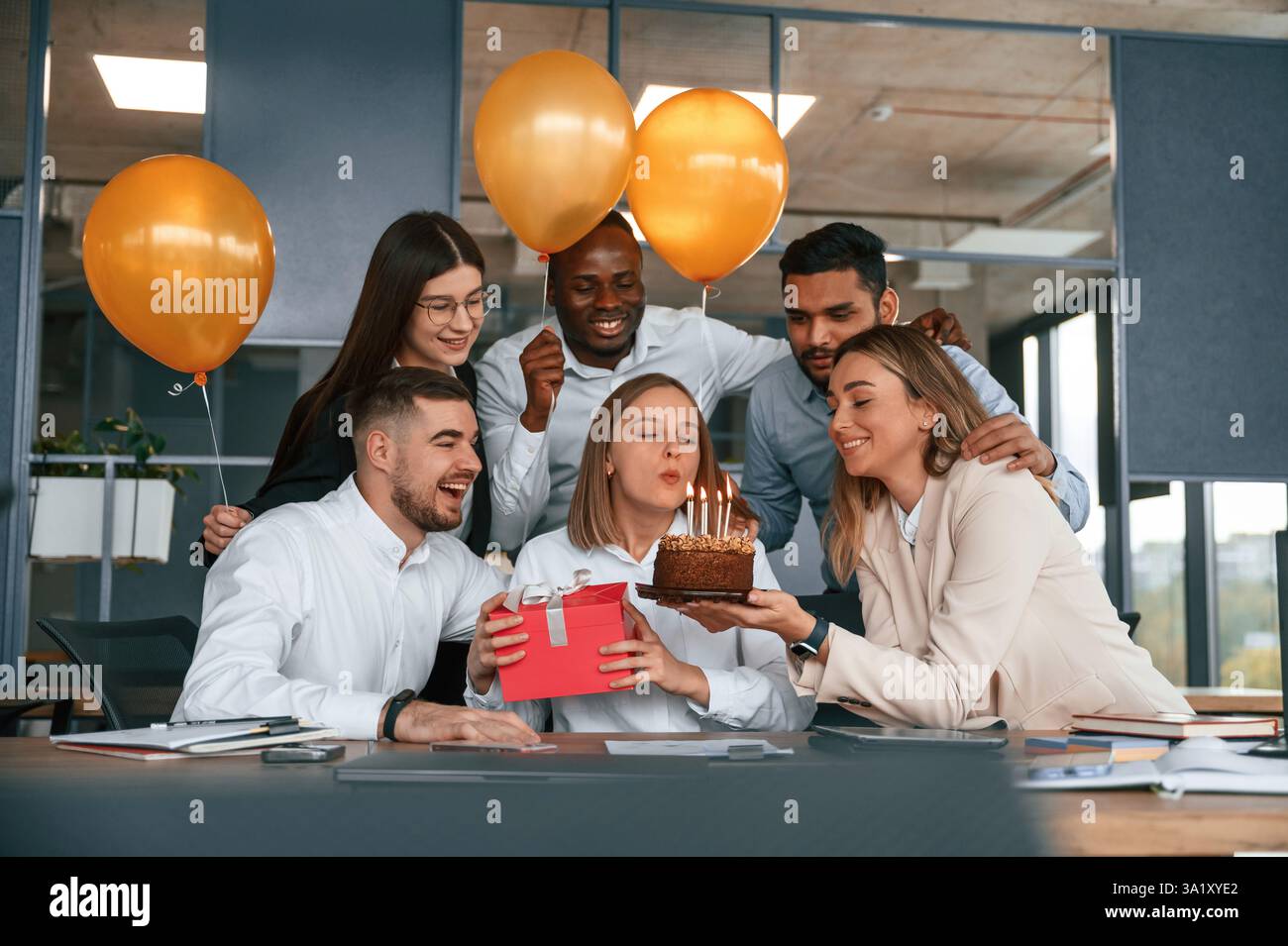 Cake with candles. Employee having a birthday in the office, group of ...