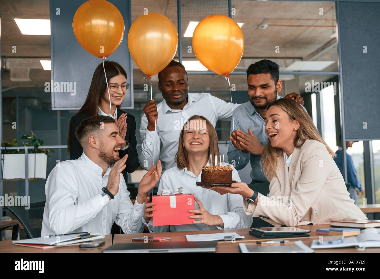 Cake with candles. Employee having a birthday in the office, group of ...