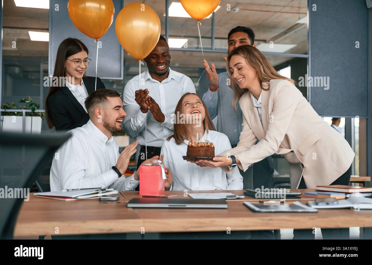 Cake with candles. Employee having a birthday in the office, group of ...