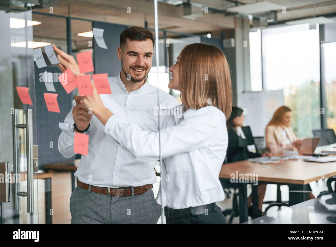 Two people are putting stickers on the glass. Planning the project ...