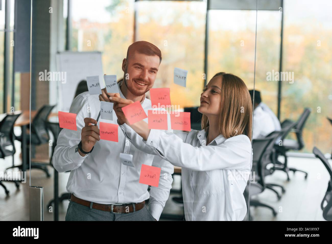 Two people are putting stickers on the glass. Planning the project ...
