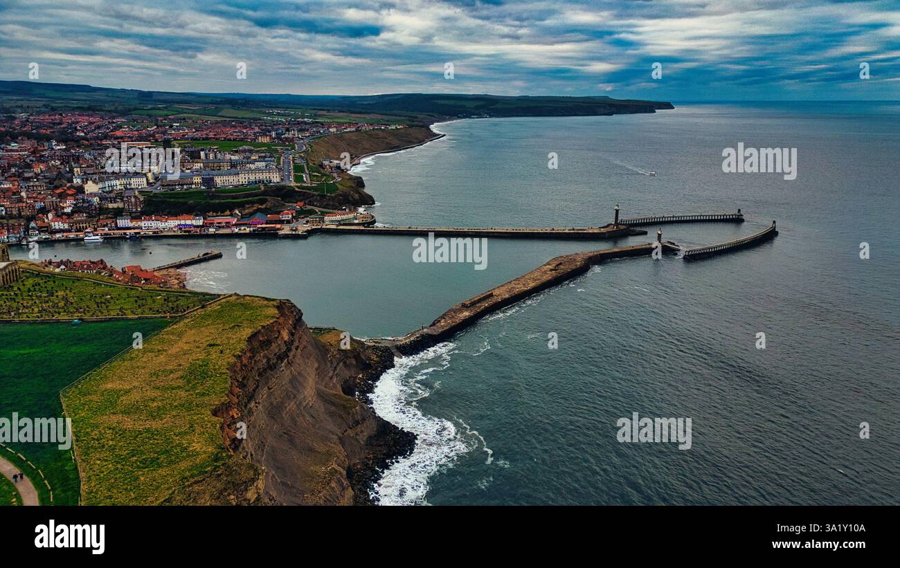 Aerial view of a coastal town featuring piers extending into the ocean ...