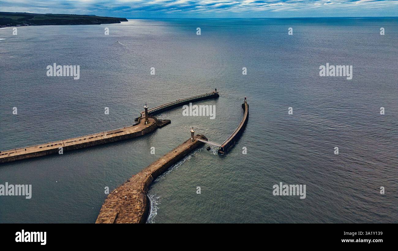 Aerial view of two piers with lighthouses extending into the ocean ...