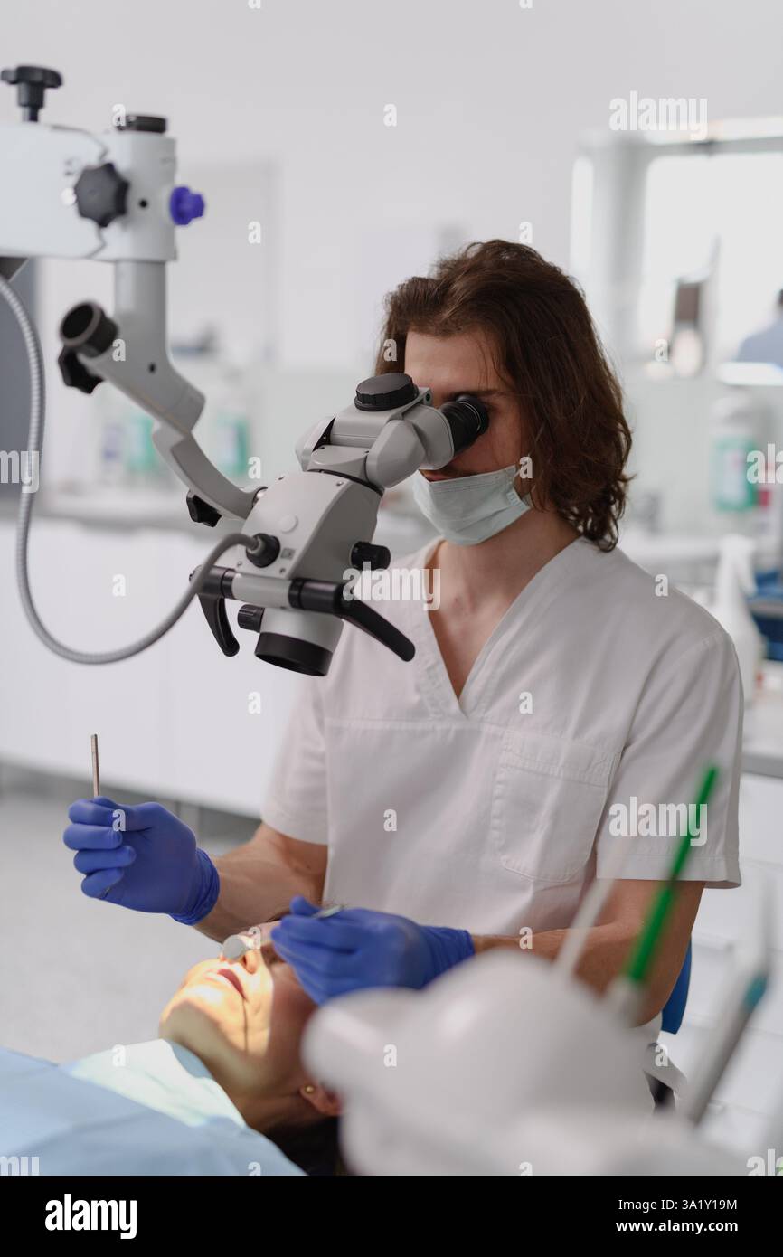 Male dentist doing dental procedure in dental clinic, using dental ...