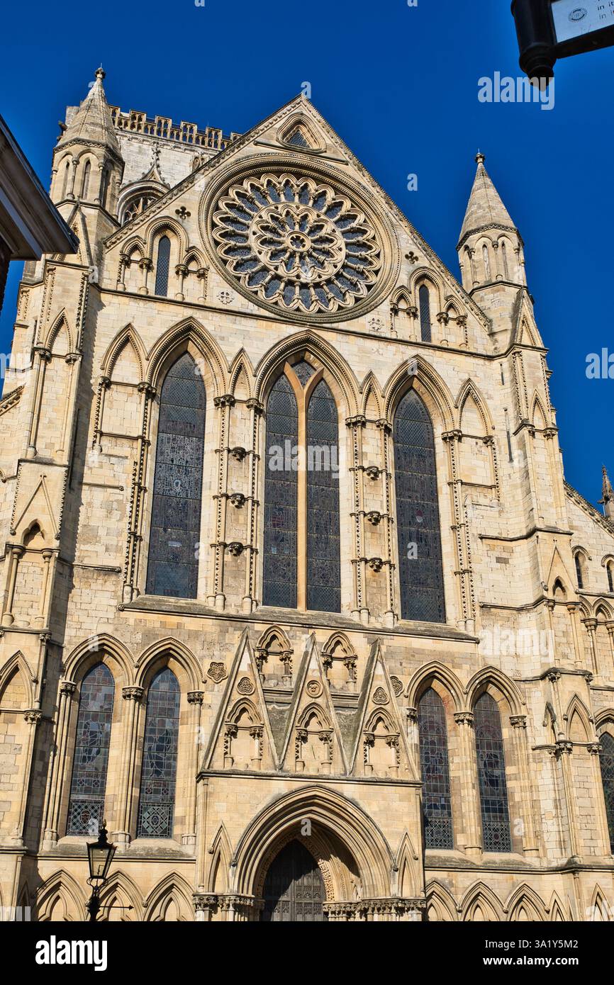 A detailed view of a beige stone cathedral facade with large stained ...