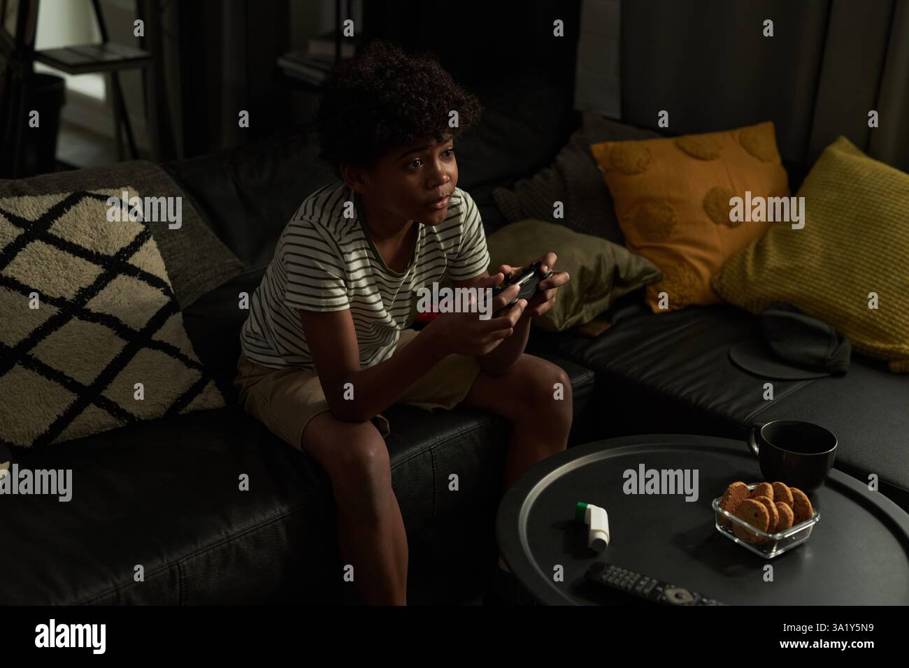 Cute African American boy with joystick in hands looking at screen of ...