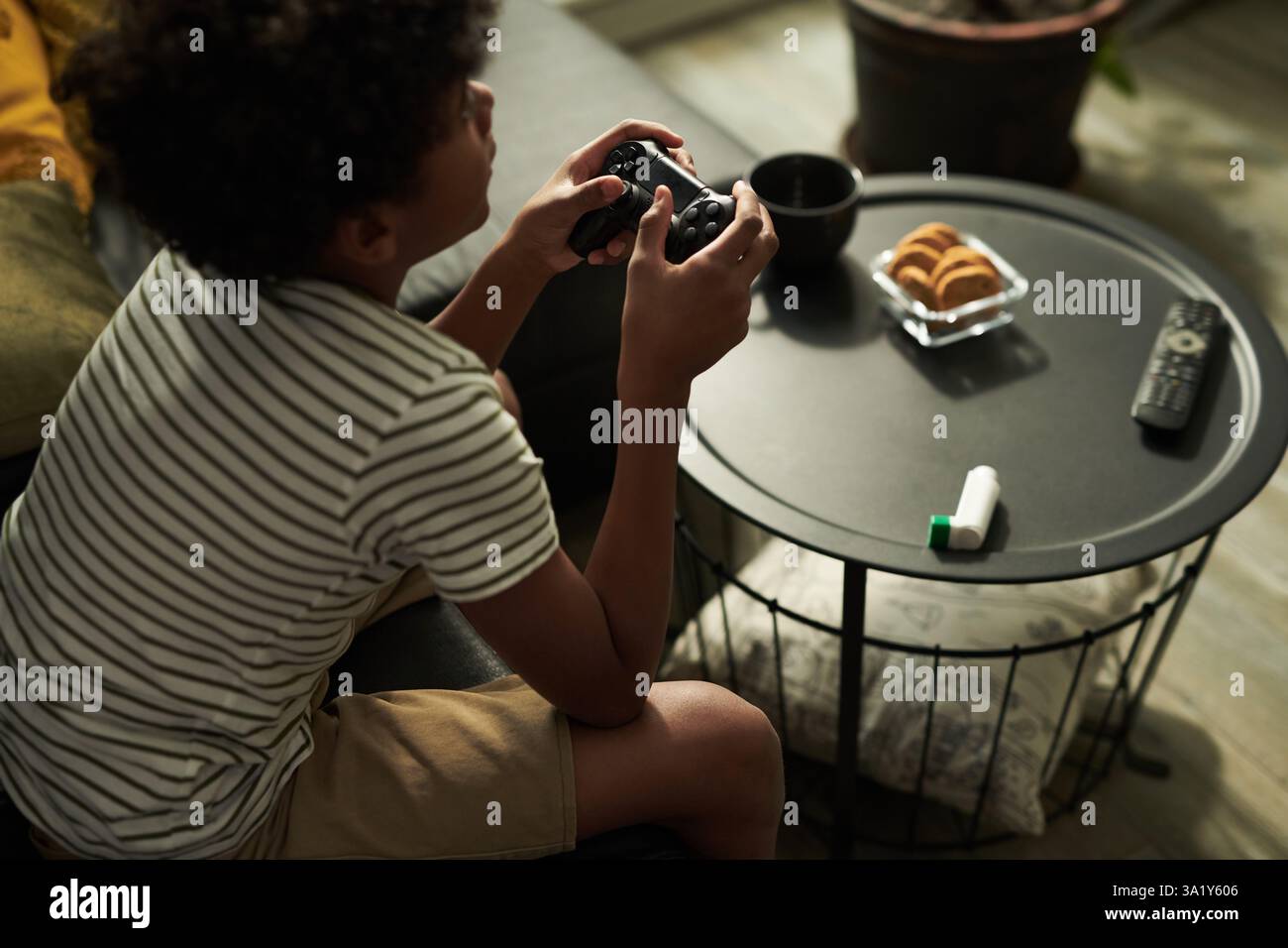 Focus on hands of youthful boy pressing buttons on joystick while ...