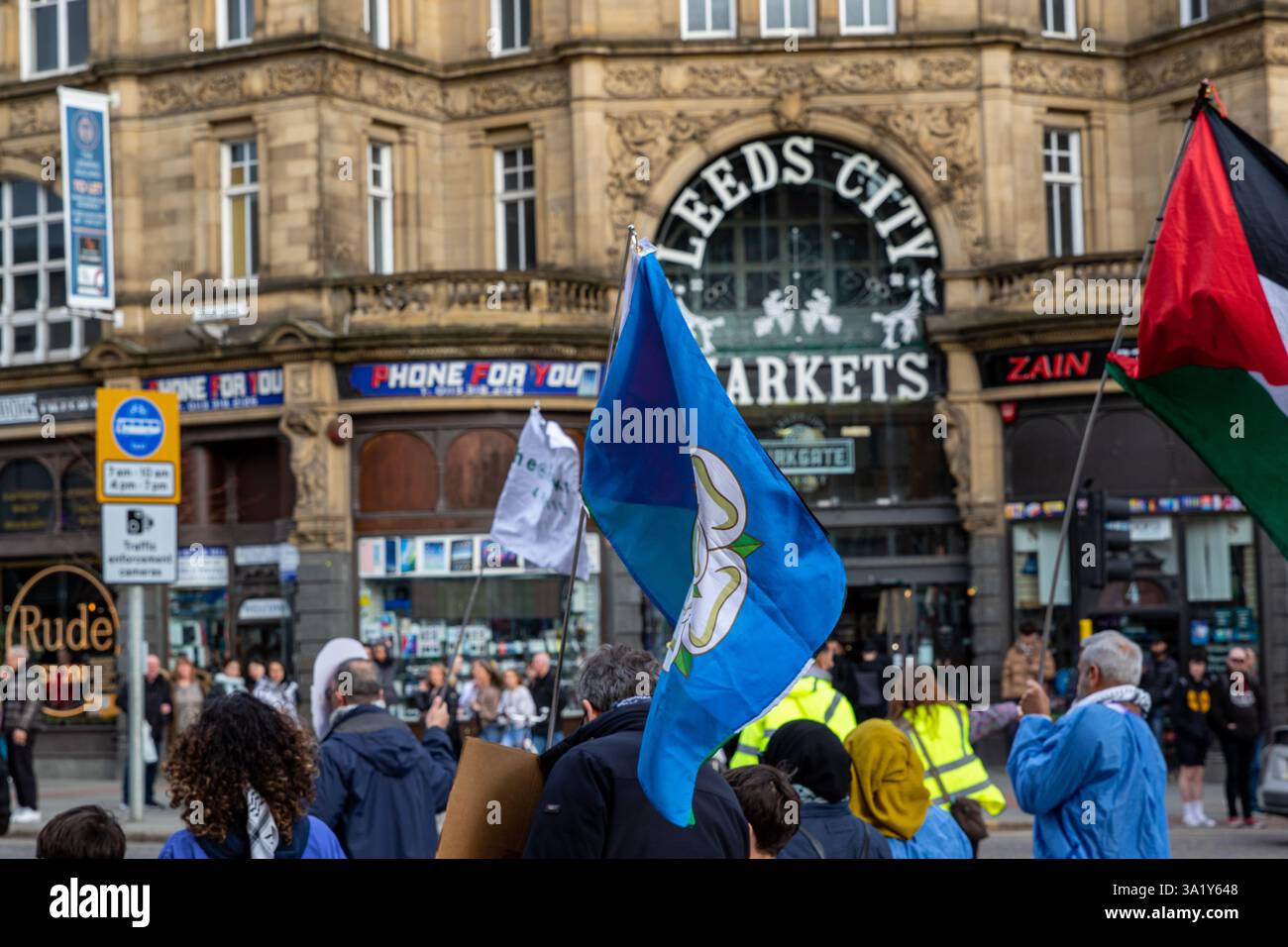 A crowd gathers with flags in front of the Leeds City Markets building ...