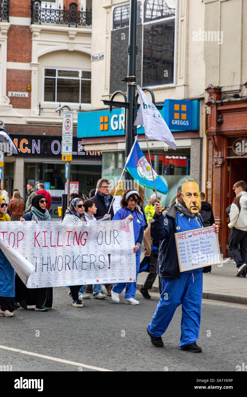 A street protest featuring people holding signs and banners in a city ...